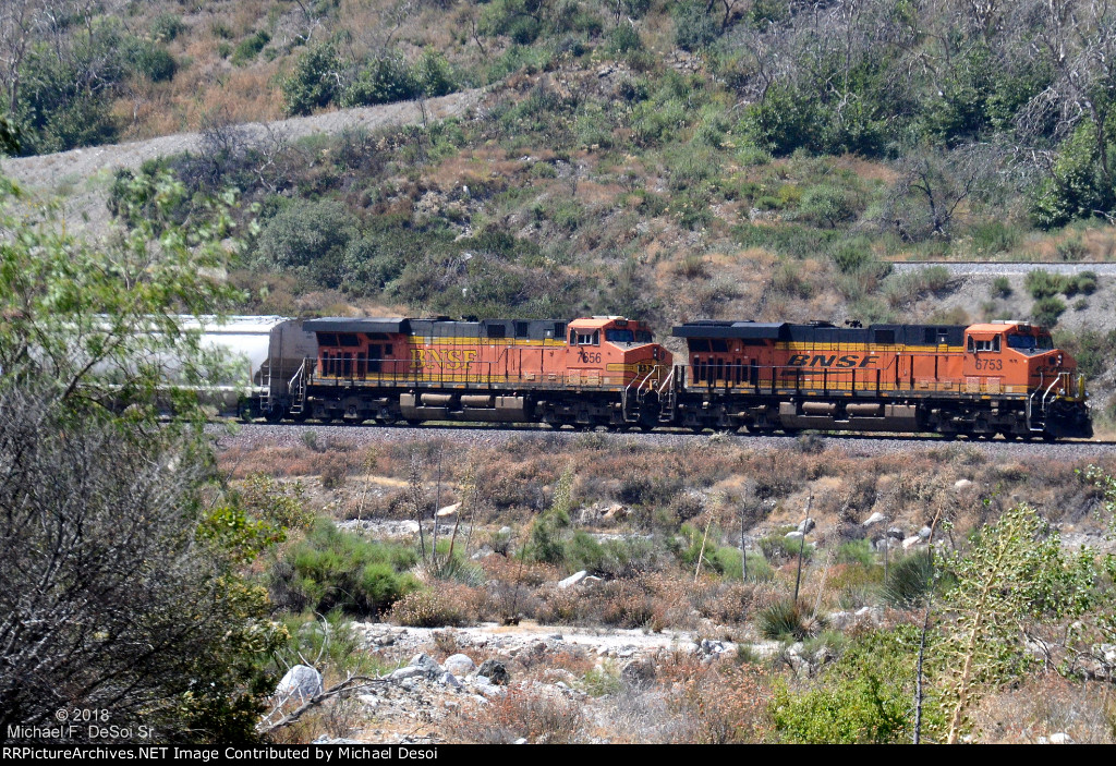 BNSF #6753, 7656 (ES-44C4, ES-44DC) are the DPUs of a westbound near Keenbrook Rd. in Cajon Pass ...